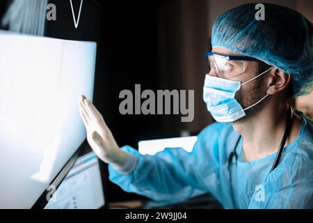 Surgeon examines fluorography images on a monitor in an operating room ...