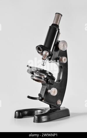 Vintage microscope on table near light wall Stock Photo - Alamy