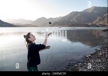 Woman putting mud on hands and face while enjoying outdoors in nature ...