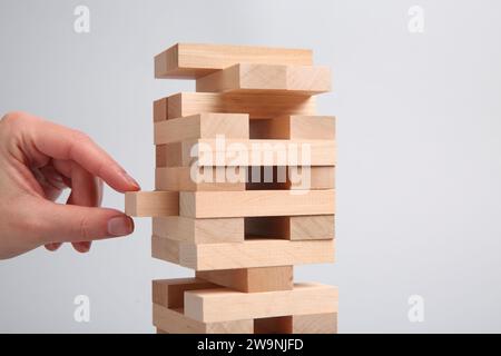 Woman playing Jenga on light gray background, closeup Stock Photo - Alamy