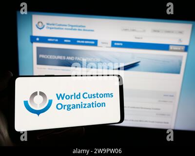 Mobile phone with logo of World Customs Organization (WCO) in front of ...