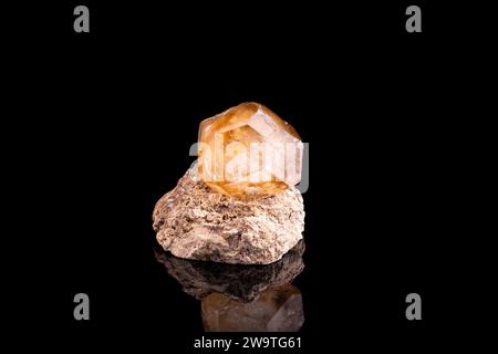 orange rhombohedral calcite on matrix isolated on black background ...