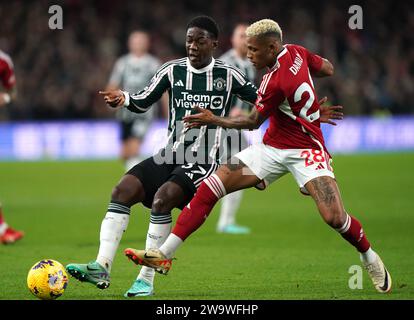 Manchester United's Kobbie Mainoo (left) warms up ahead of the Premier ...