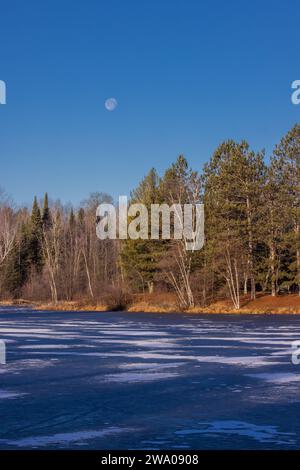 The moon setting over Loretta Lake in northern Wisconsin Stock Photo ...