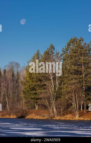 The moon setting over Loretta Lake in northern Wisconsin Stock Photo ...