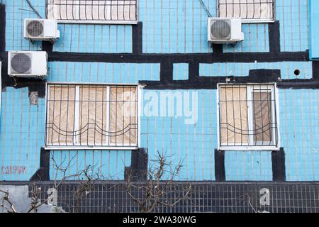 Residential building after a blast wave with broken windows covered ...