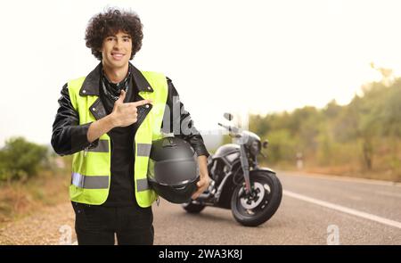 Biker holding a helmet and wearing a traffic safety vest isolated on ...