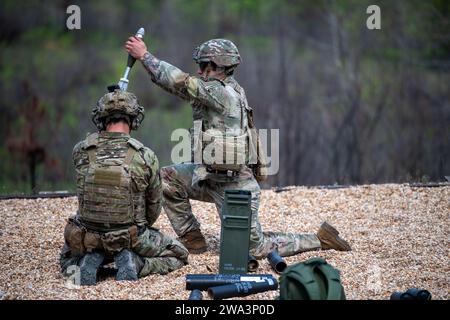 Soldiers aim and shoot a handheld and bipod-stabilized 60mm mortar ...