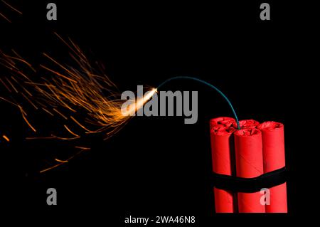 A bundle of dynamite with lit fuse again black background Stock Photo ...