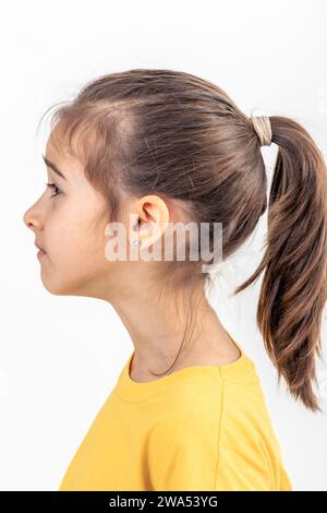 side view of girl in shirt and shorts holding laptop isolated on blue ...