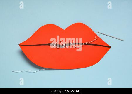 Sewn paper lips on blue background. Domestic violence concept Stock ...