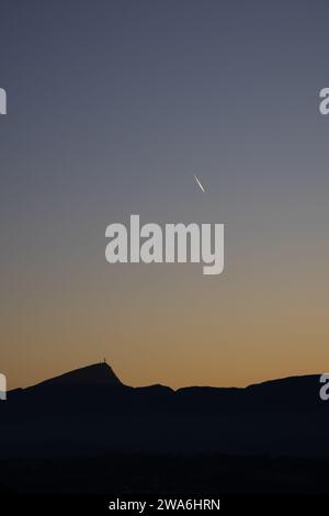 Jet exhaust of a single plane crossing a cloudless sky over moutain ...