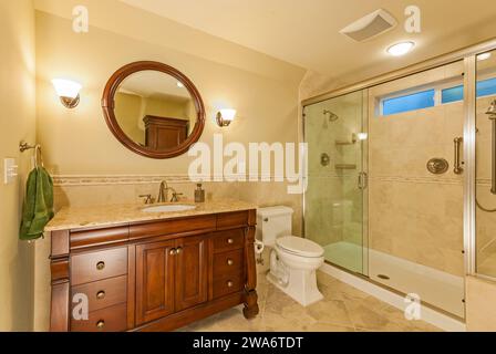 Remodeled bathroom in a middle-class home. A piece of wooden furniture ...