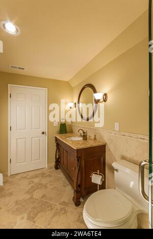 Remodeled bathroom in a middle-class home. A piece of wooden furniture ...