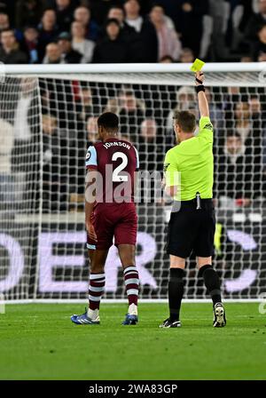 Referee Samuel Barrott shows a yellow card to Bayern's Hiroki Ito ...