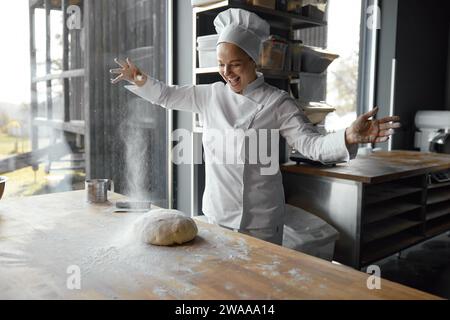 Baker throwing bread dough in bakery Stock Photo - Alamy