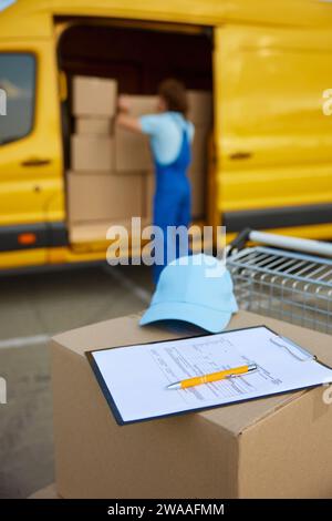 Man loader packing boxes into minivan, focus on delivery checklist and ...