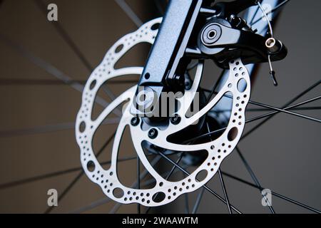 Part of the bicycle's braking system. Grey metal brake disc and brake ...