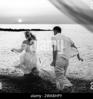 Bride and groom drinking wine at sunset Stock Photo - Alamy