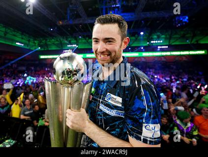 Luke Littler celebrates with the trophy after victory in the final ...