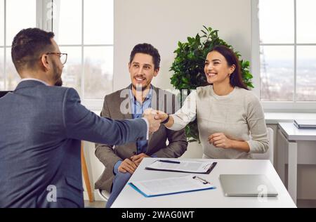 Male real estate agent with handshake smiling in white real estate room ...