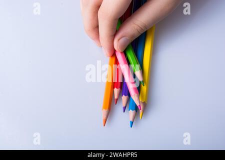 Hand holding color Pencils placed on a white background Stock Photo - Alamy
