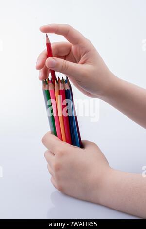child hand hold pencils color on white background Stock Photo - Alamy