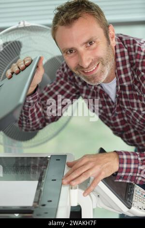 happy man fixing a printing machine Stock Photo - Alamy