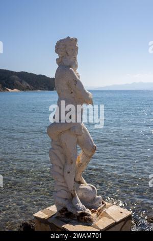 Calm and clean Ionian sea. Statue of Nereus in the harbor. Glittering ...