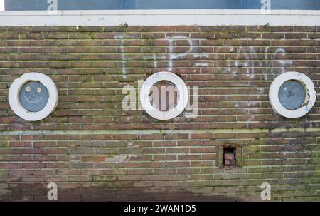Round concrete windows or port holes mounted into the brick base of the ...