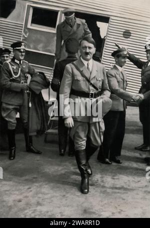 A photograph of Adolf Hitler standing outside the side door of a German ...