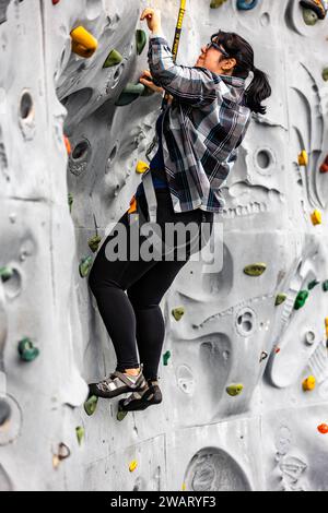 An active female scaling a challenging indoor rock wall Stock Photo - Alamy