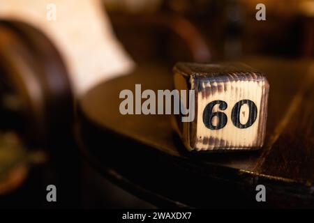 The number 60 on the wooden cube is burned with large symbols Stock ...