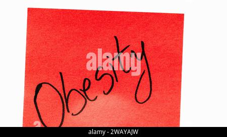 Obesity handwriting text close up isolated on orange paper with copy ...