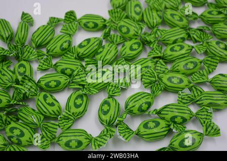 Bright, colorful factory menthol candies packed in green packaging with ...