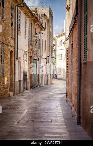 Narrow historic street lined with colorful pastel houses and blue ...
