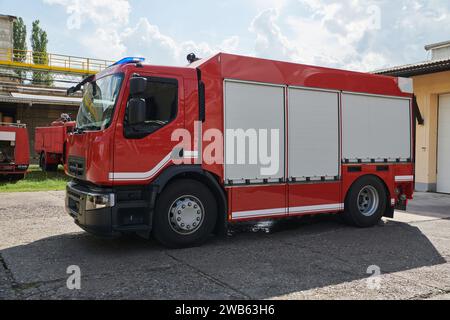 A firefighter stands ready with rescue tools in the foreground, facing ...