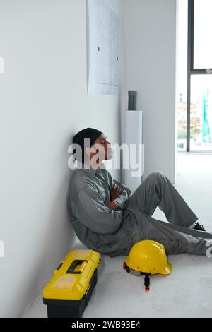Exhausted construction worker resting in a house under renovation Stock ...