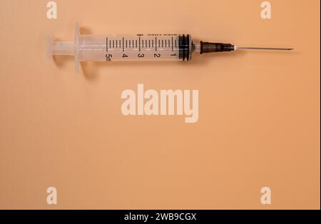 Empty 5ml syringe with needle on peach background. Copy Space Stock ...