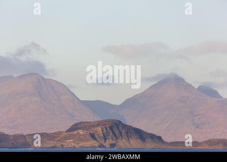 The small island of Muck with the mountains of the Isle of Rum seen ...