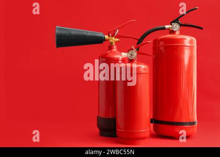 Fire extinguishers on red background Stock Photo - Alamy