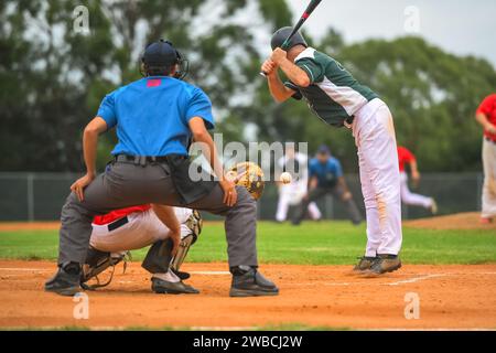 Men playing baseball game. Batter getting ready to hit a pitch during ...