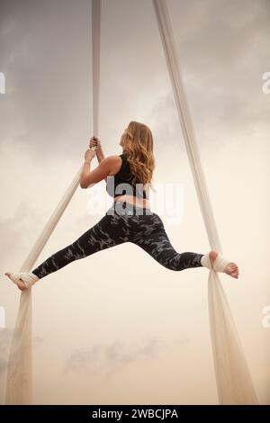 Female aerialist performing on aerial silk outdoors Stock Photo - Alamy