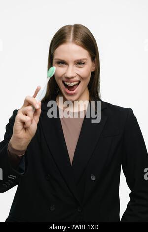 The girl smiles widely, holding a toothbrush in her hands and showing ...