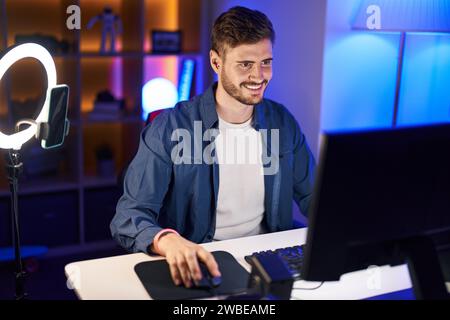 Young caucasian man streamer playing video game using computer at ...