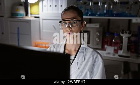 Young hispanic woman wearing scientist uniform working at laboratory ...