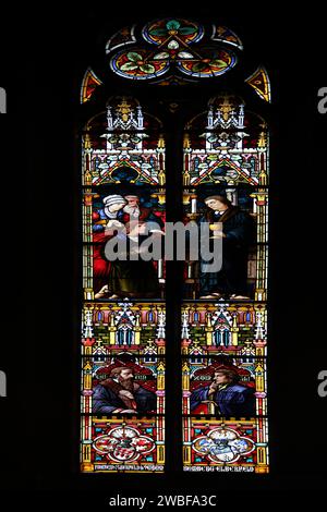 Colourful stained glass window with reformers Martin Luther with quill ...
