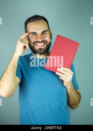 Young hispanic man holding books and world ball clueless and confused ...