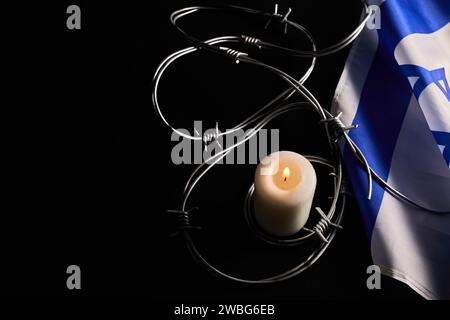 Burning candle with flag of Israel and barbed wire on dark background ...