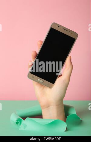 Hand breaking through pink paper wall with clenched fist. Conceptual ...